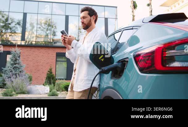 Adult man using a mobile application on smartphone to charge an ...