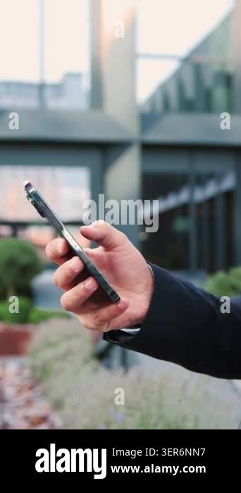 Male hands holding smartphone and laptop walking at downtown area ...