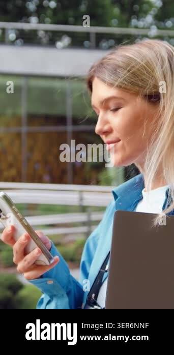 Young caucasian business woman using cell phone mobile app and holding ...
