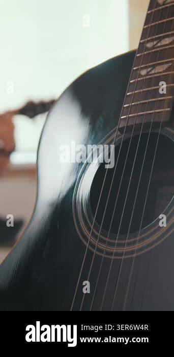 Young attractive guy musician composes music on the guitar and play ...