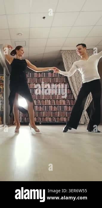 Young attractive man and woman dancing and practicing Latin dance in ...