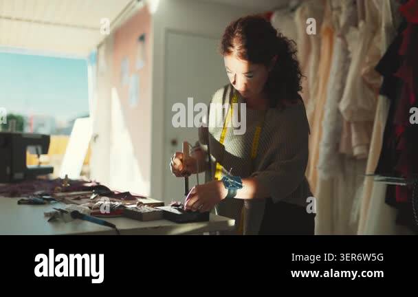 A person is busy sewing in a studio. They are focused on their work and ...
