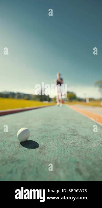 A student is seen preparing for a shot put throw on a track field. The ...