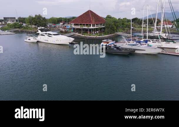 Serene harbor with yachts and sailboats at rest. White vessel glides ...