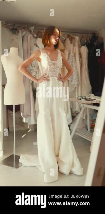 Young woman looking at her reflection in the mirror while fitting a ...