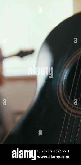 Young attractive man musician composes music on the guitar and play ...
