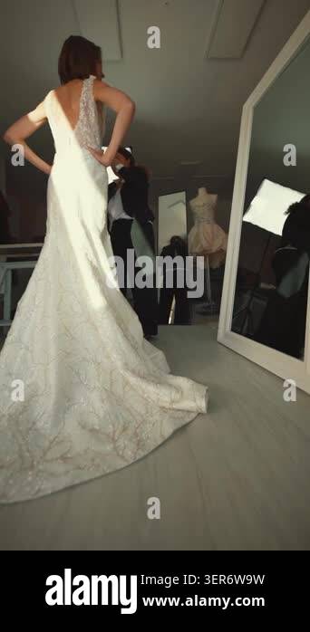 Young woman admiring her reflection in a mirror while fitting a ...
