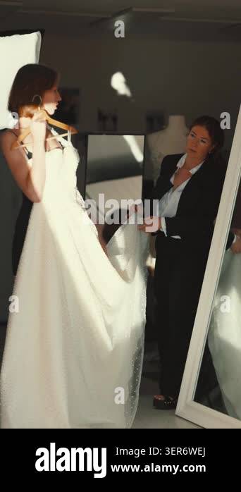 Future bride choosing the perfect white wedding dress with a stylist in ...