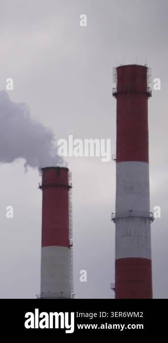 The pipe with smoke in cloudy sky - chemical industry, telephoto shot ...