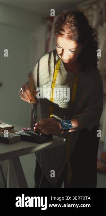 Focused woman using a special tool to shape and create detailed ...
