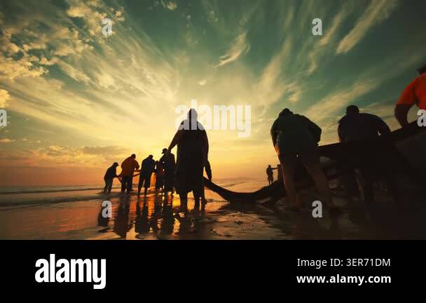 Group of traditional fishermen working together to haul a dragnet from ...