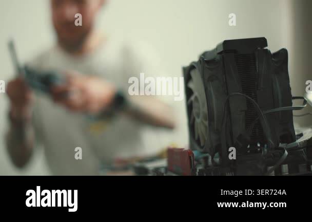 Focused computer processor cooler fan with a blurred technician working ...
