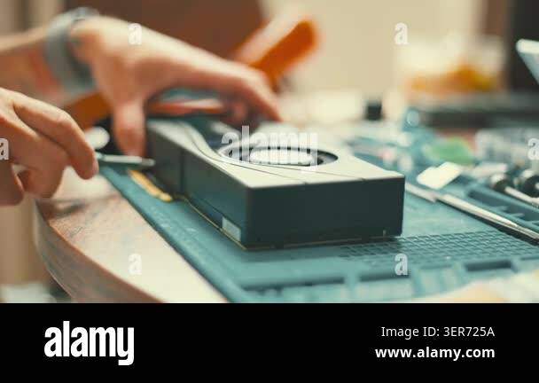 Professional technician disassembling a modern gpu with a screwdriver ...