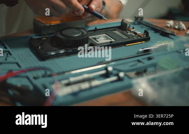 Close-up of a technicians hands applying new thermal paste to a ...