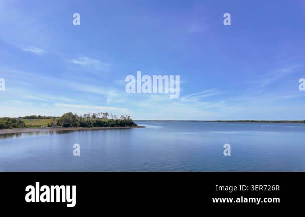 Slow motion footage of scenic shoreline and calm coastal waters viewed ...