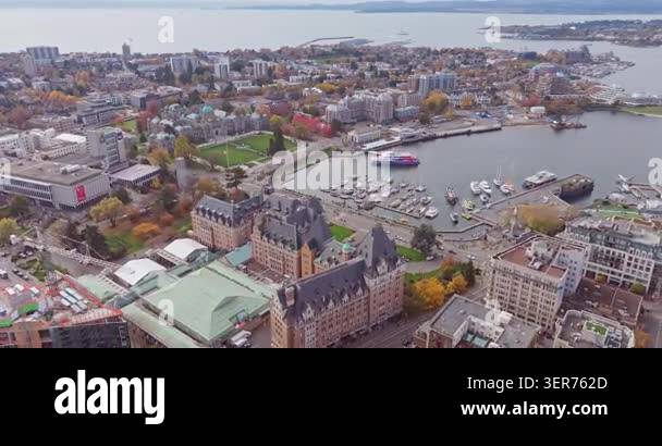 Aerial drone view of a bustling city harbor with boats docked and a ...