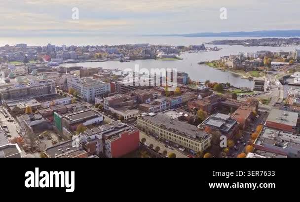 Aerial drone footage flying over a city with a harbor and distant ...