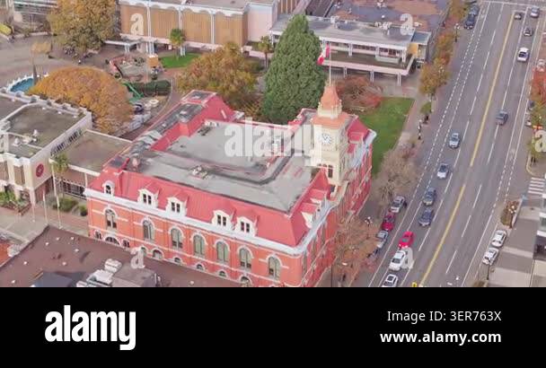 Aerial drone footage flying over a historic red-roofed building with a ...