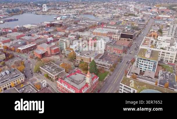 Aerial drone footage flying over a dense city with a harbor in the ...