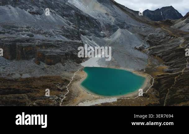 Aerial view of hidden curved Milk Lake in mountain ravine of Daocheng ...