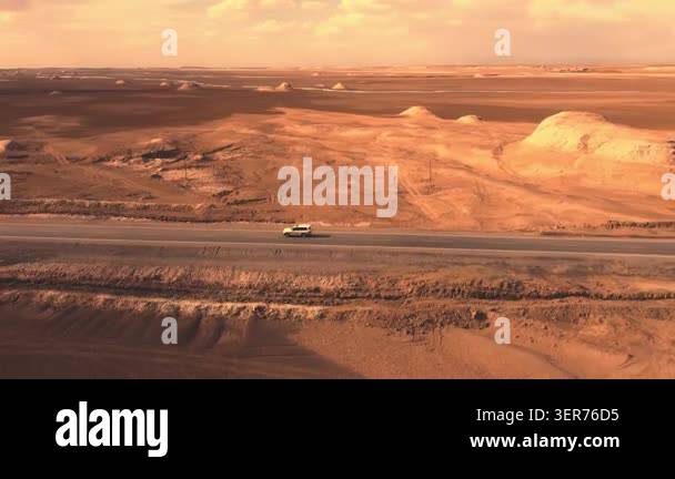 Aerial Shot of Car Driving on Highway Through Yardang Landform in ...