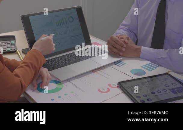 Business colleagues are analyzing a line chart showing marketing and ...