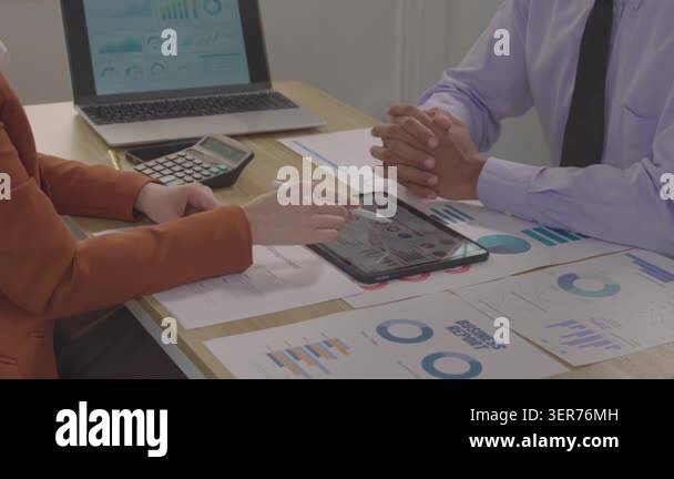 Business colleagues are analyzing a line chart showing marketing and ...