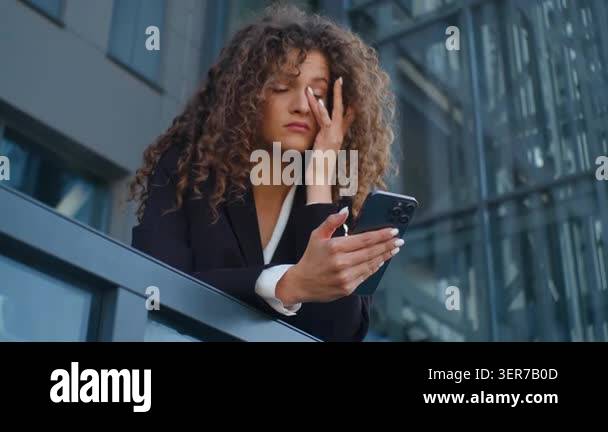 Stressed Caucasian business woman using mobile phone feeling headache ...
