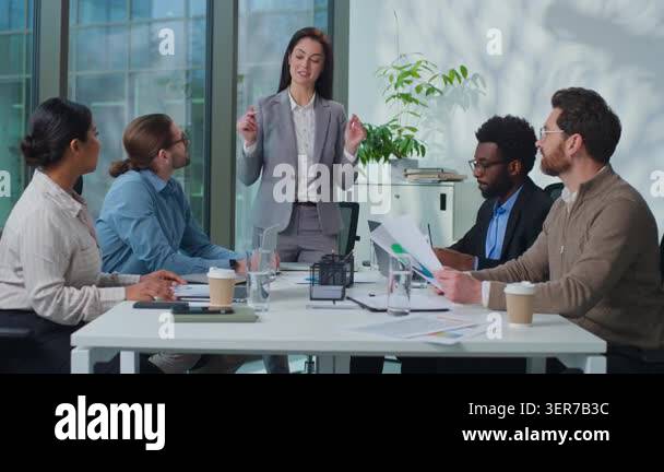 Caucasian businesswoman talking to successful business team coworkers ...