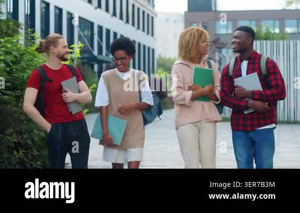 Four multiethnic students walking talking laughing happy go to study ...