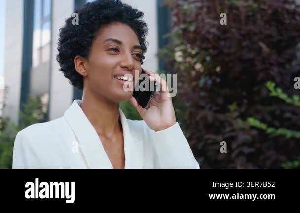 Positive African American business woman happy talking mobile phone ...