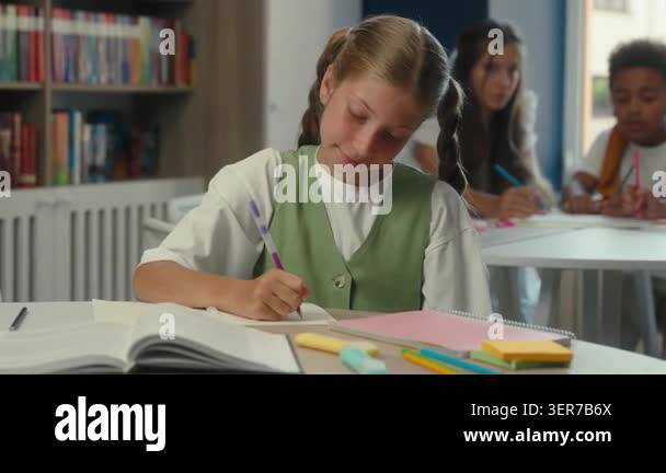 Caucasian child kid girl schoolgirl writing homework studying showing ...