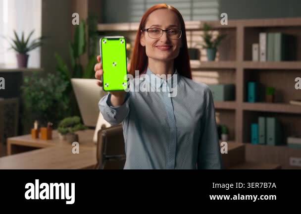 Happy Caucasian business woman holding mobile phone green screen mockup ...