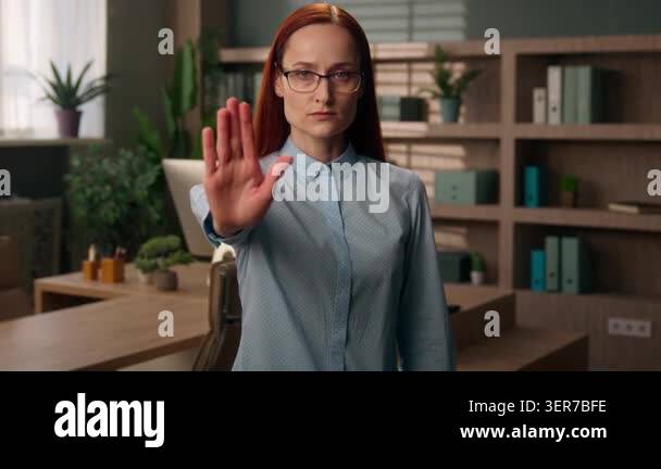 Serious Caucasian business woman showing stop gesture with hand looking ...