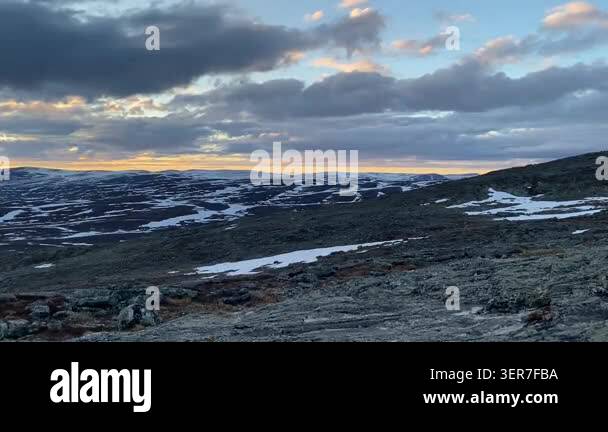 Panoramic view of frozen mountain lake and snow covered peaks under ...