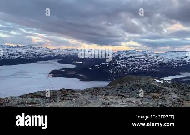 Panoramic view of frozen mountain lake and snow covered peaks under ...