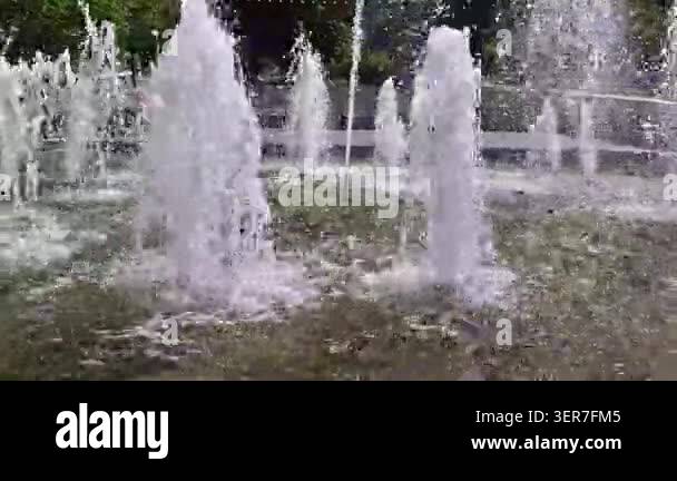 Multiple water jets spray vertically creating a misty splash in a ...