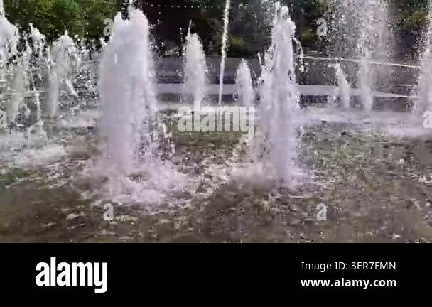 Multiple streams of water spray vertically from a circular fountain in ...