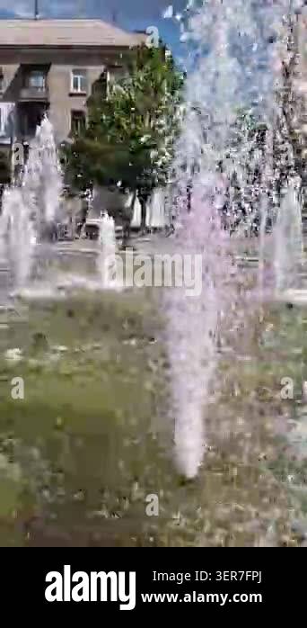 Sparkling water droplets burst powerfully upwards from active public ...
