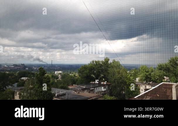 Distant industrial chimneys release dark smoke over residential ...