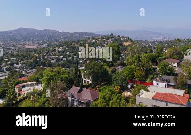 Flying over Los Angeles residential neighborhood with green hills ...