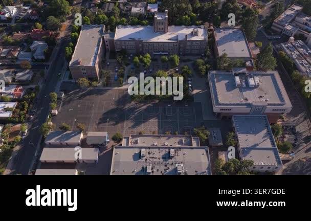 Top down orbit shot showcasing historic brick school building with ...