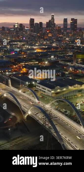 Aerial footage of evening cityscape. Backwards reveal of illuminated ...