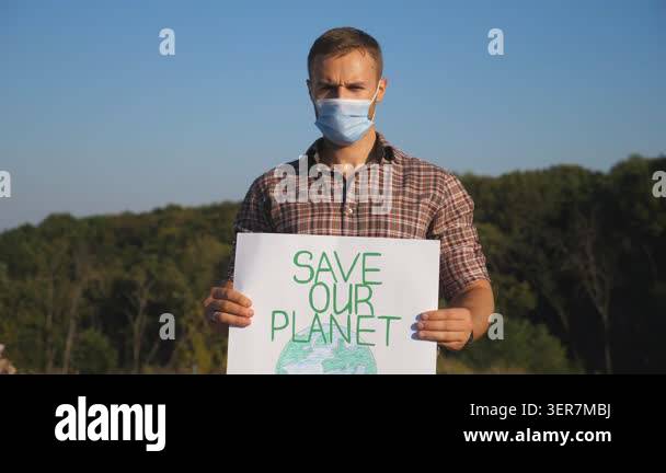 Portrait of young man holding in hands poster of environmental movement ...