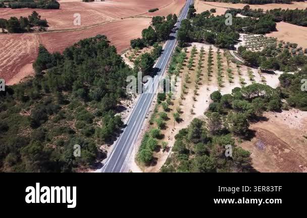 Aerial view of winding country road crossing forest and agricultural ...