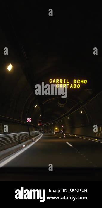 Vertical video of a car driving through a modern, illuminated highway ...