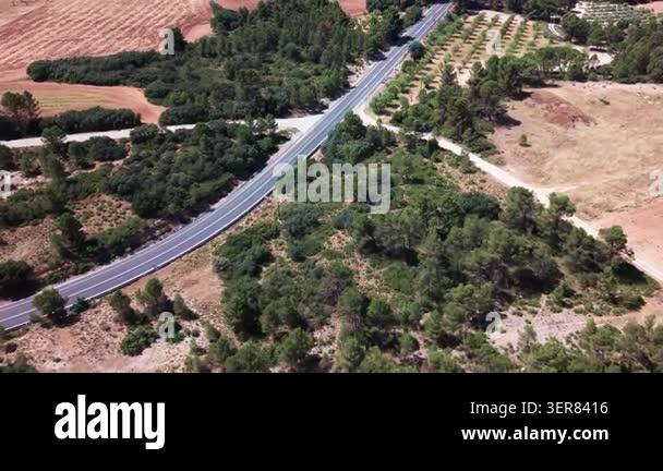 Aerial view of winding country road crossing forest and agricultural ...