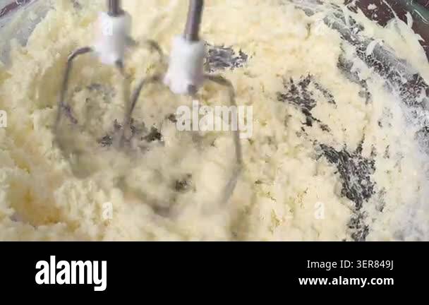 Electric mixer whips smooth buttercream frosting into a light fluffy ...