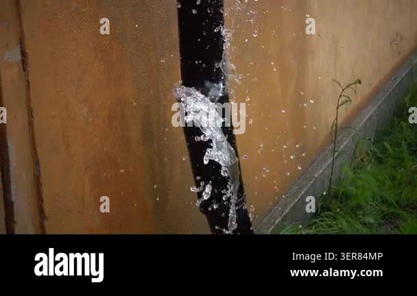 Stockholm, Sweden A leaky drain pipe in heavy rain spews out water onto ...