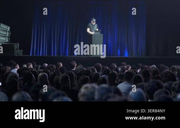 Large audience watches speaker on stage during conference presentation ...